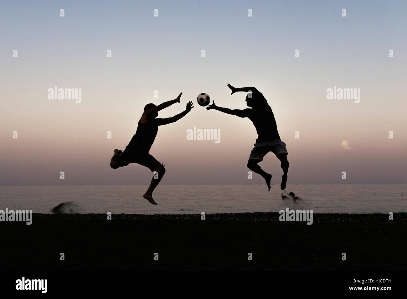 Two friends playing soccer in the beach Stock Photo - Alamy