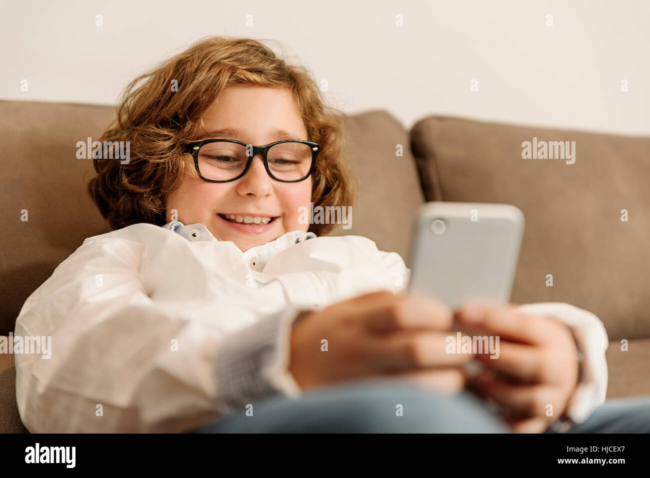 Child boy using his mobile phone at home Stock Photo - Alamy
