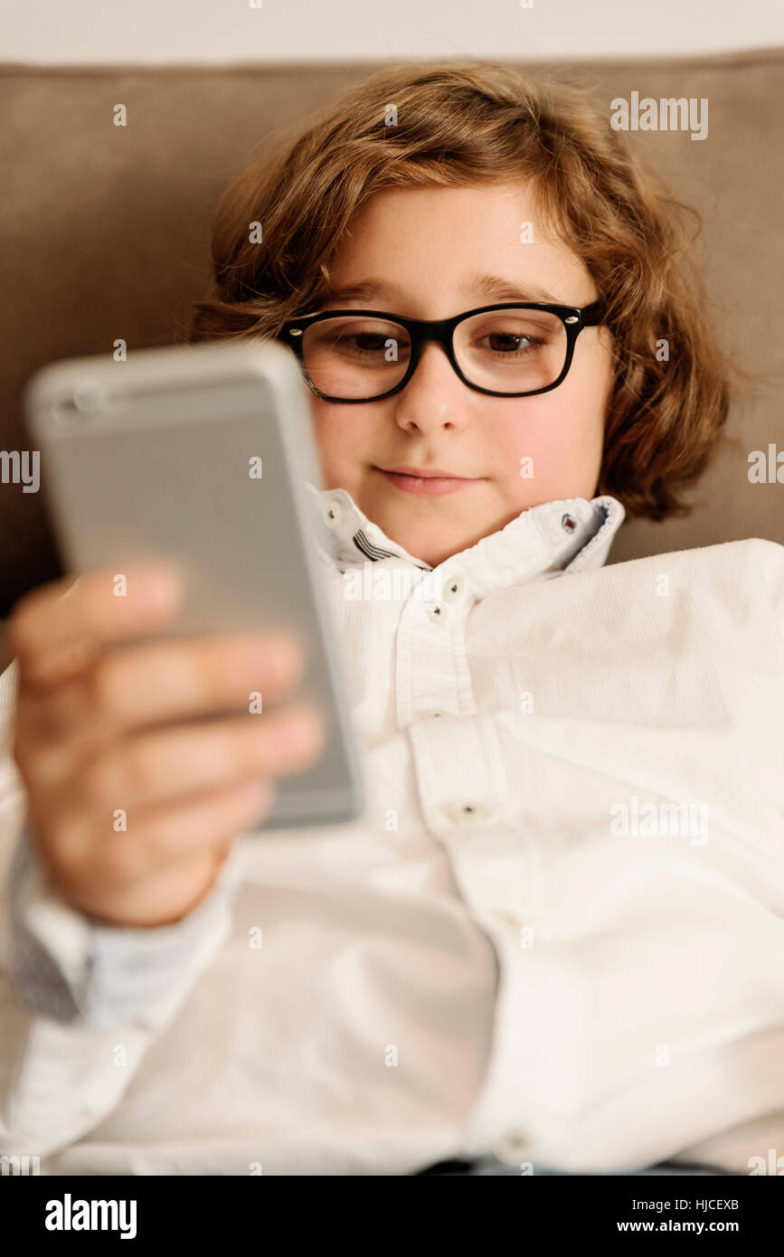 Child boy using his mobile phone at home Stock Photo - Alamy