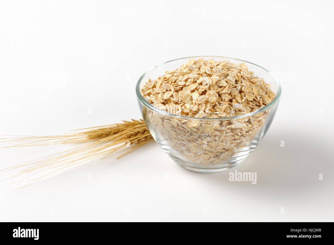 bowl of oat flakes on off-white background with shadows Stock Photo - Alamy