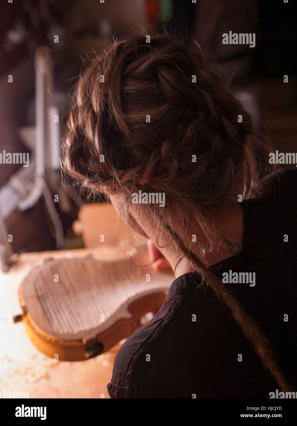 Woman violin maker, luthier, at work in her laboratory in Cremona ...