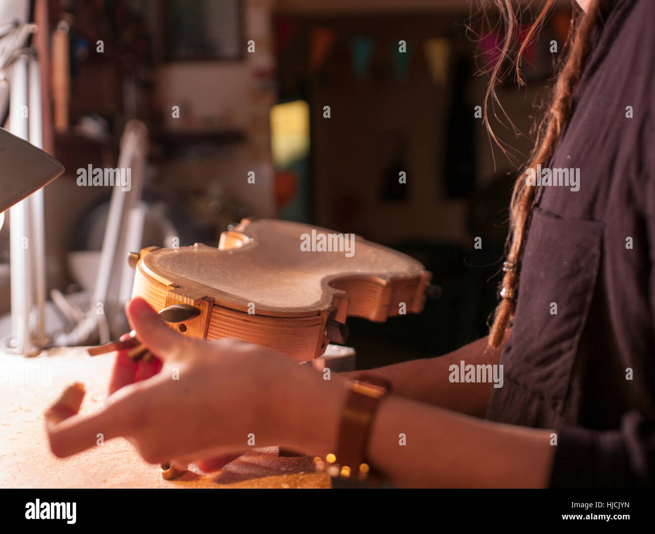 Woman violin maker, luthier, at work in her laboratory in Cremona ...