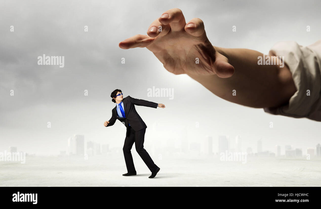 funny image of businessman trying to run away from hand Stock Photo - Alamy