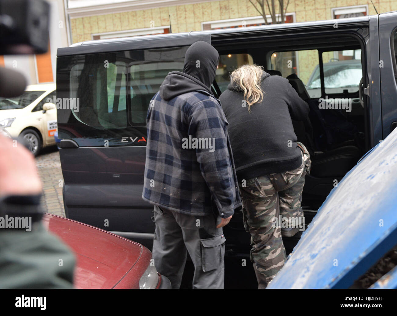 Berlin, Germany. 25th Jan, 2017. Policemen let a man enter a car during ...
