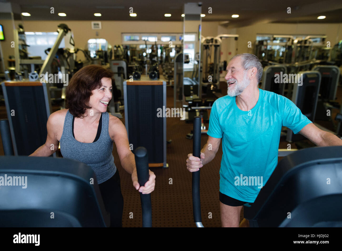 Beautiful fit senior couple in gym doing cardio work out Stock Photo ...