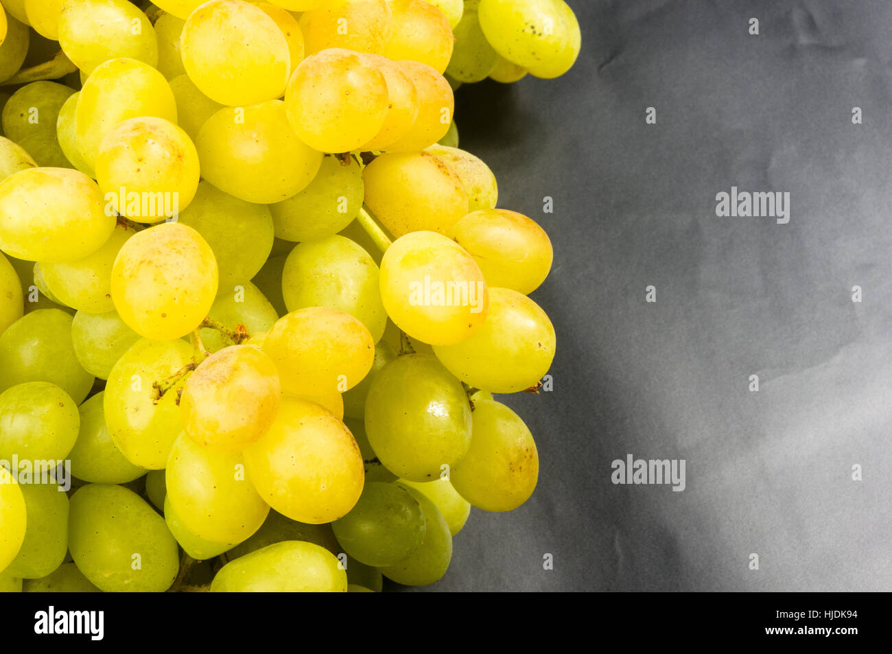 Large grapes cluster amber color on black background Stock Photo - Alamy
