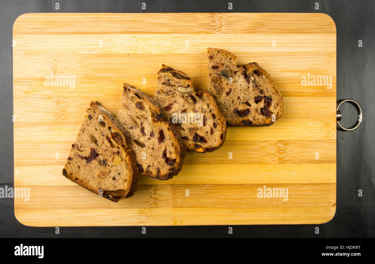 Slices of malt bread handmade with nuts, raisins and cranberries on ...