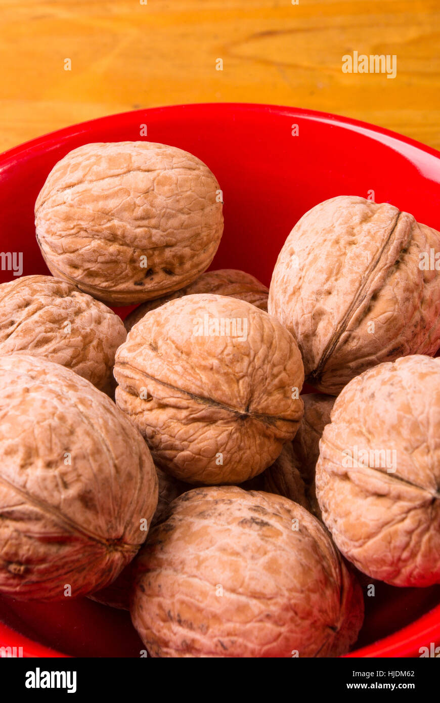 walnuts in red plate on wooden background Stock Photo - Alamy