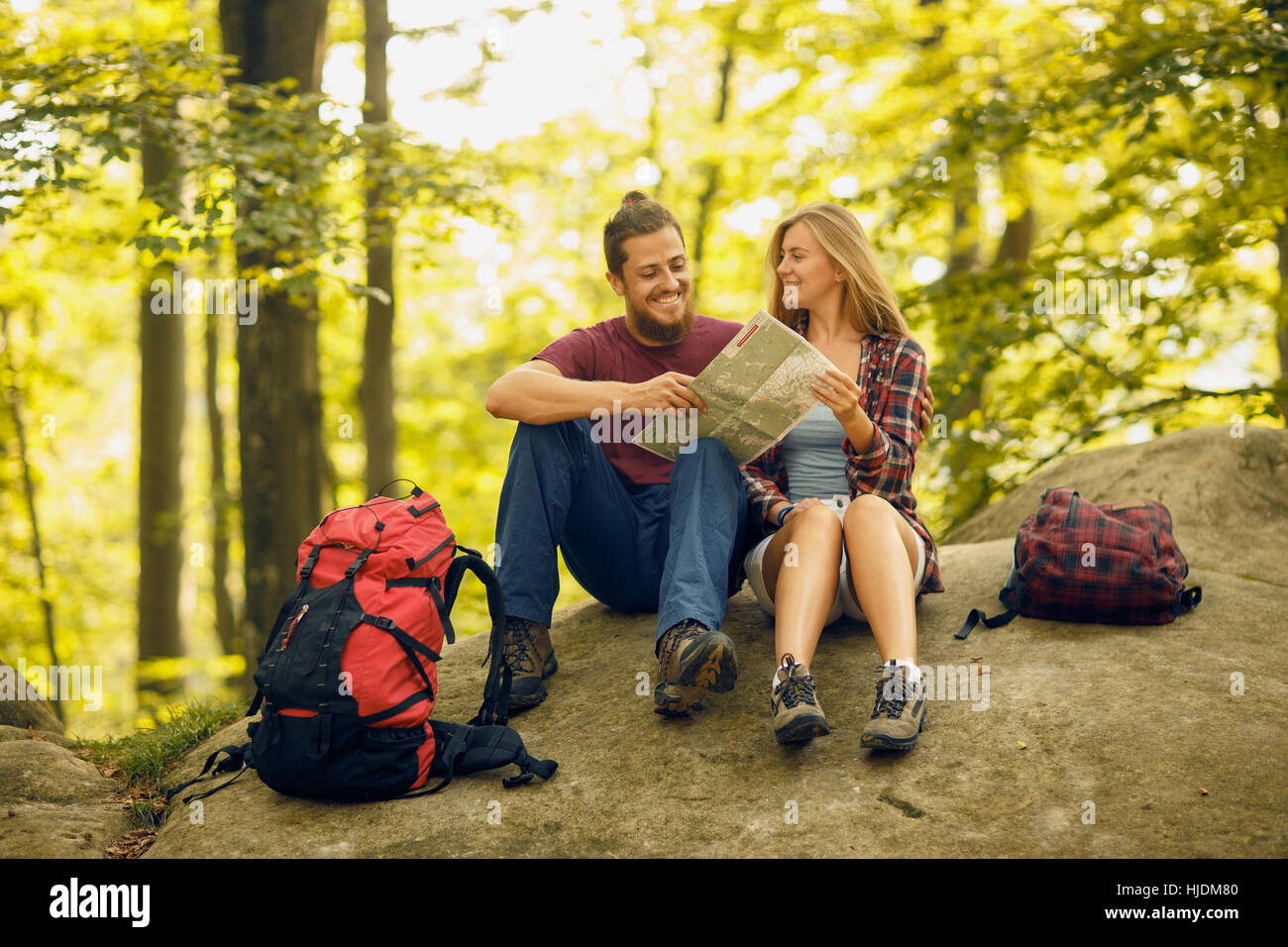 Smiling couple trying to find them location using a map Stock Photo - Alamy