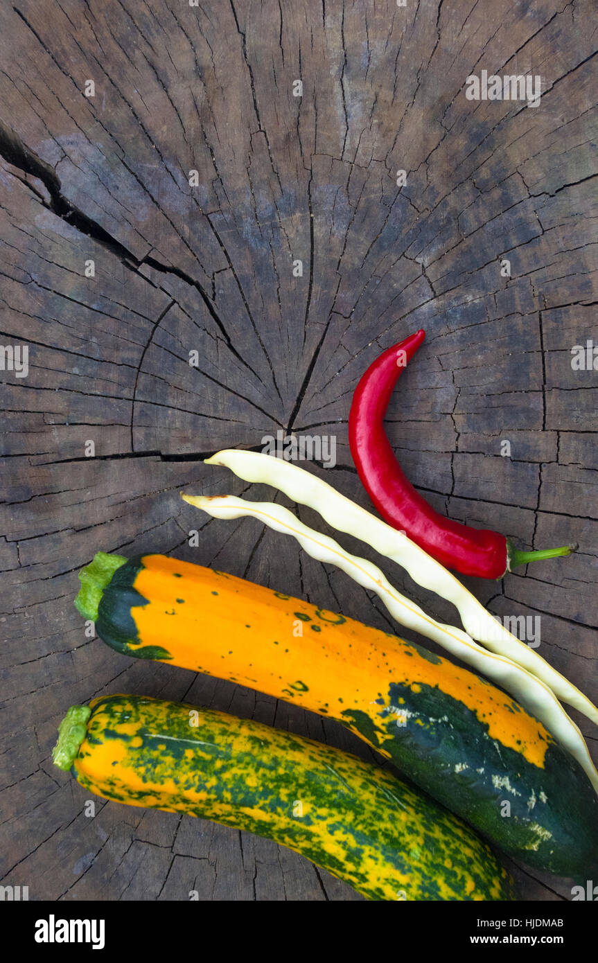 unusual green-orange zucchini, pods of white beans and red chilly on an ...