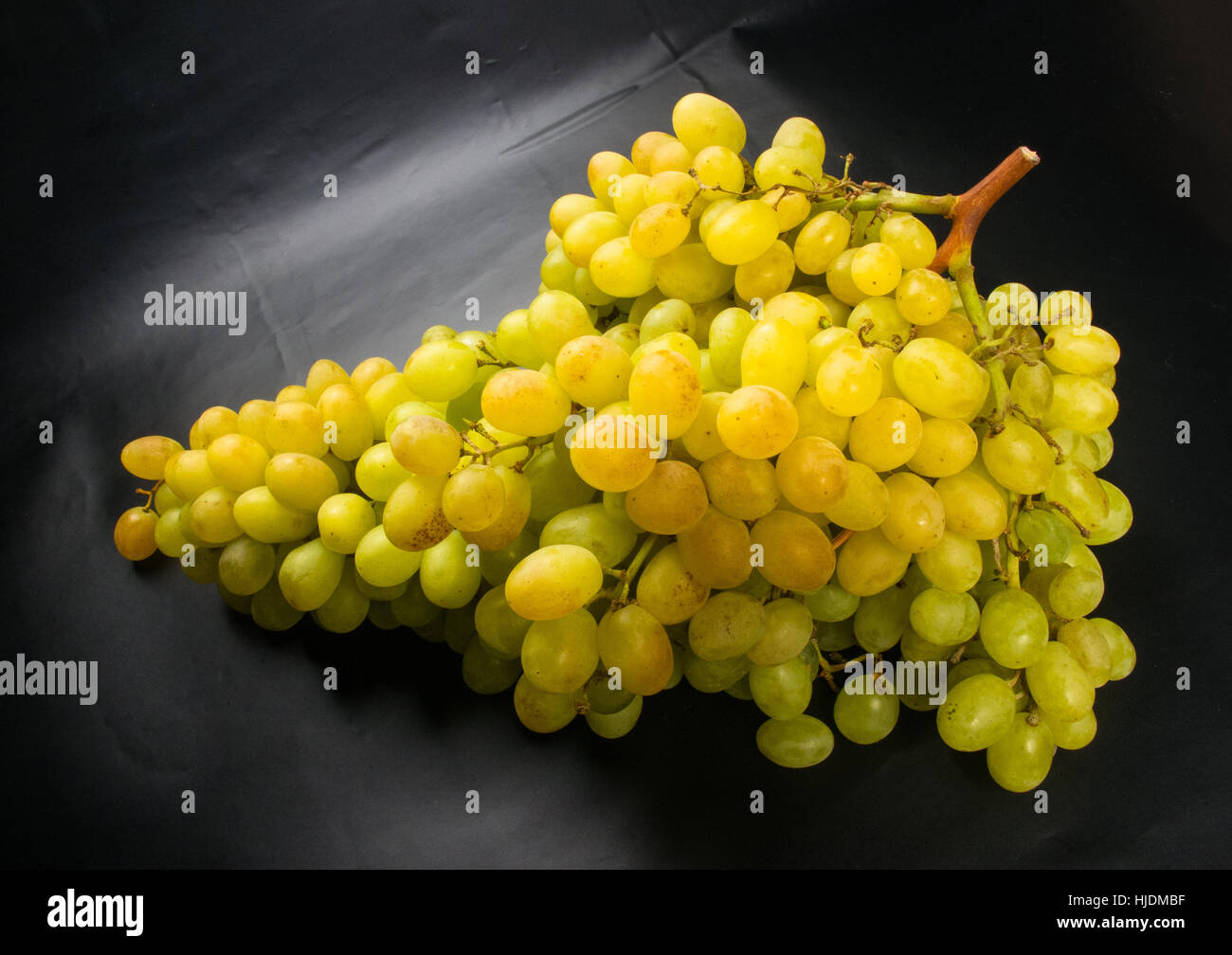 Large grapes cluster amber color on black background Stock Photo - Alamy