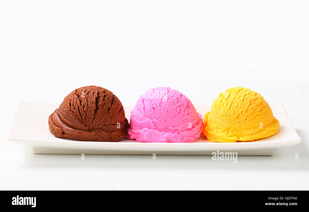 Three scoops of ice cream on a long plate Stock Photo - Alamy