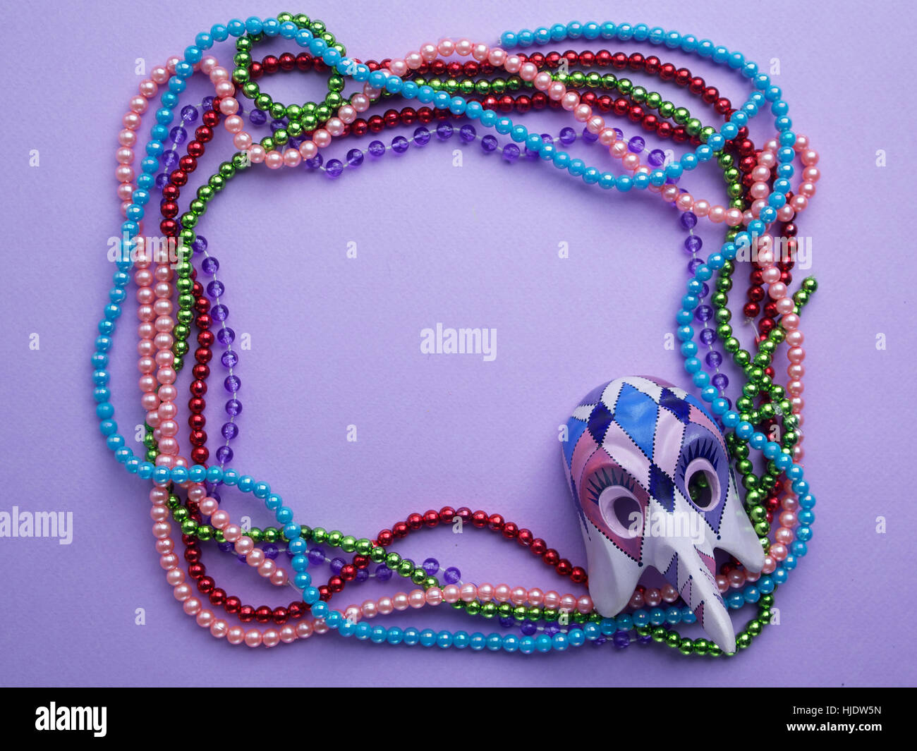 Mardi Gras beads and mask making a frame with copy space on purple ...