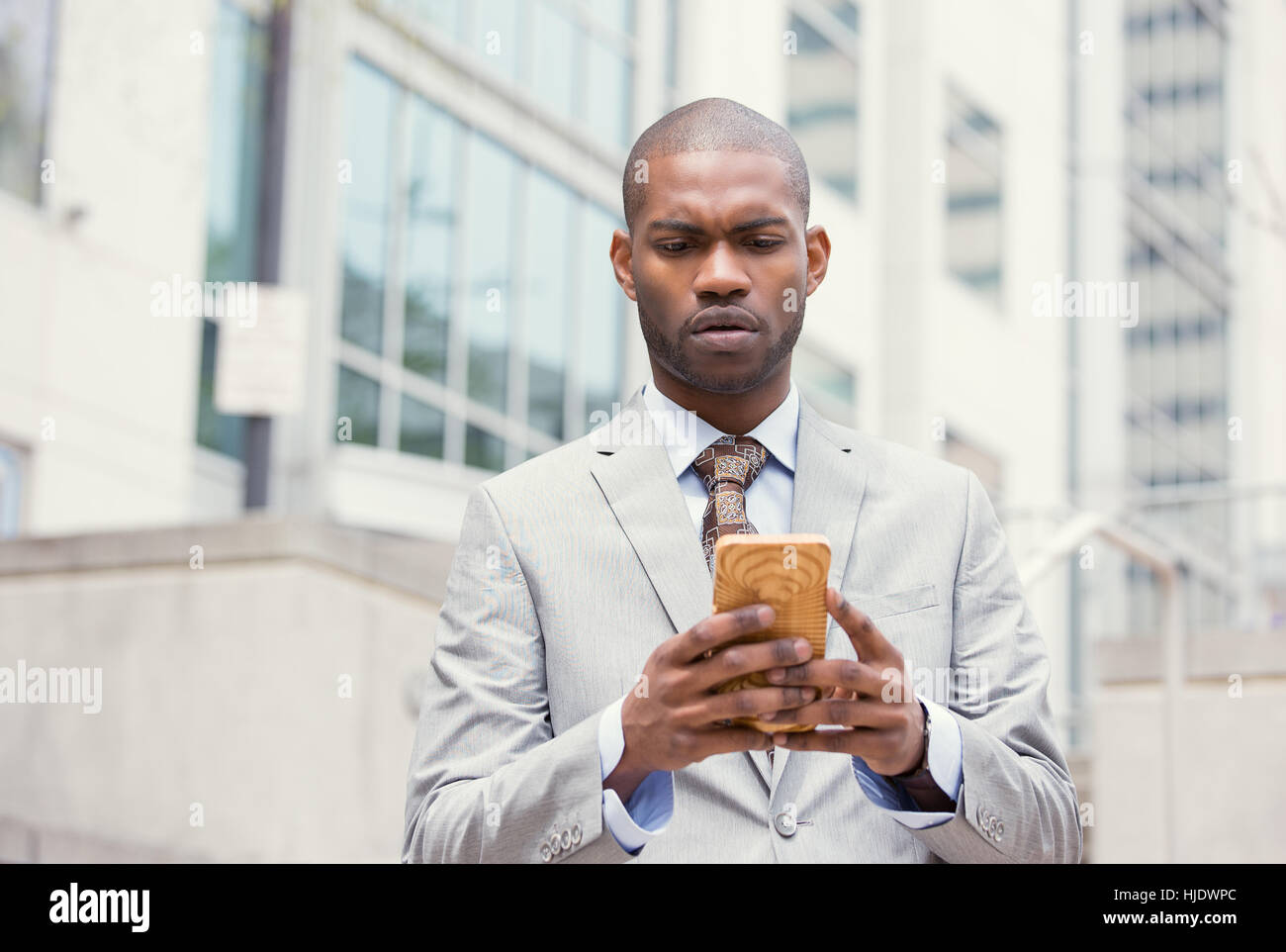 Portrait upset worried unhappy serious young man talking texting on ...