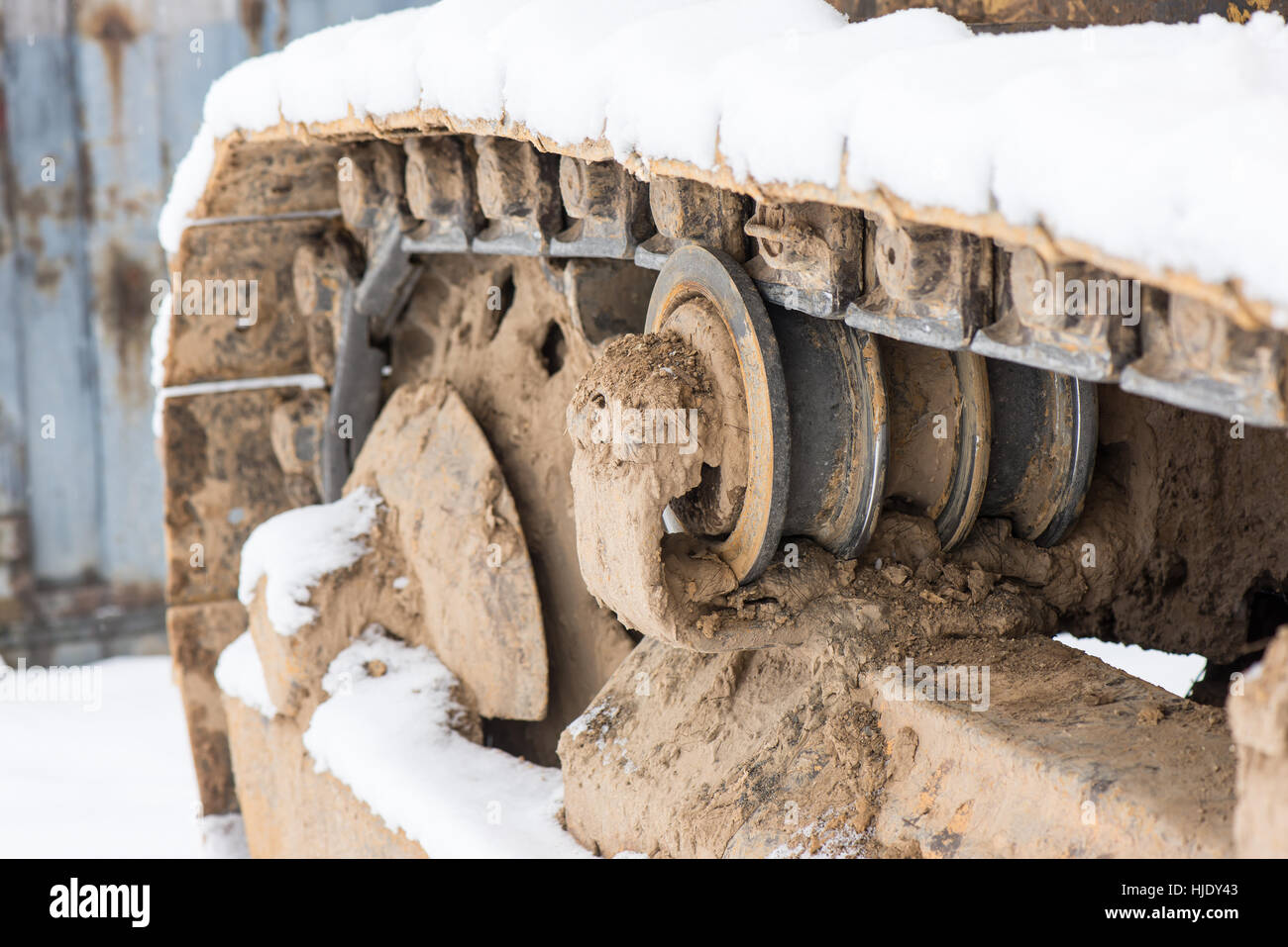 Detail of caterpillar track in construction site with dust and snow ...