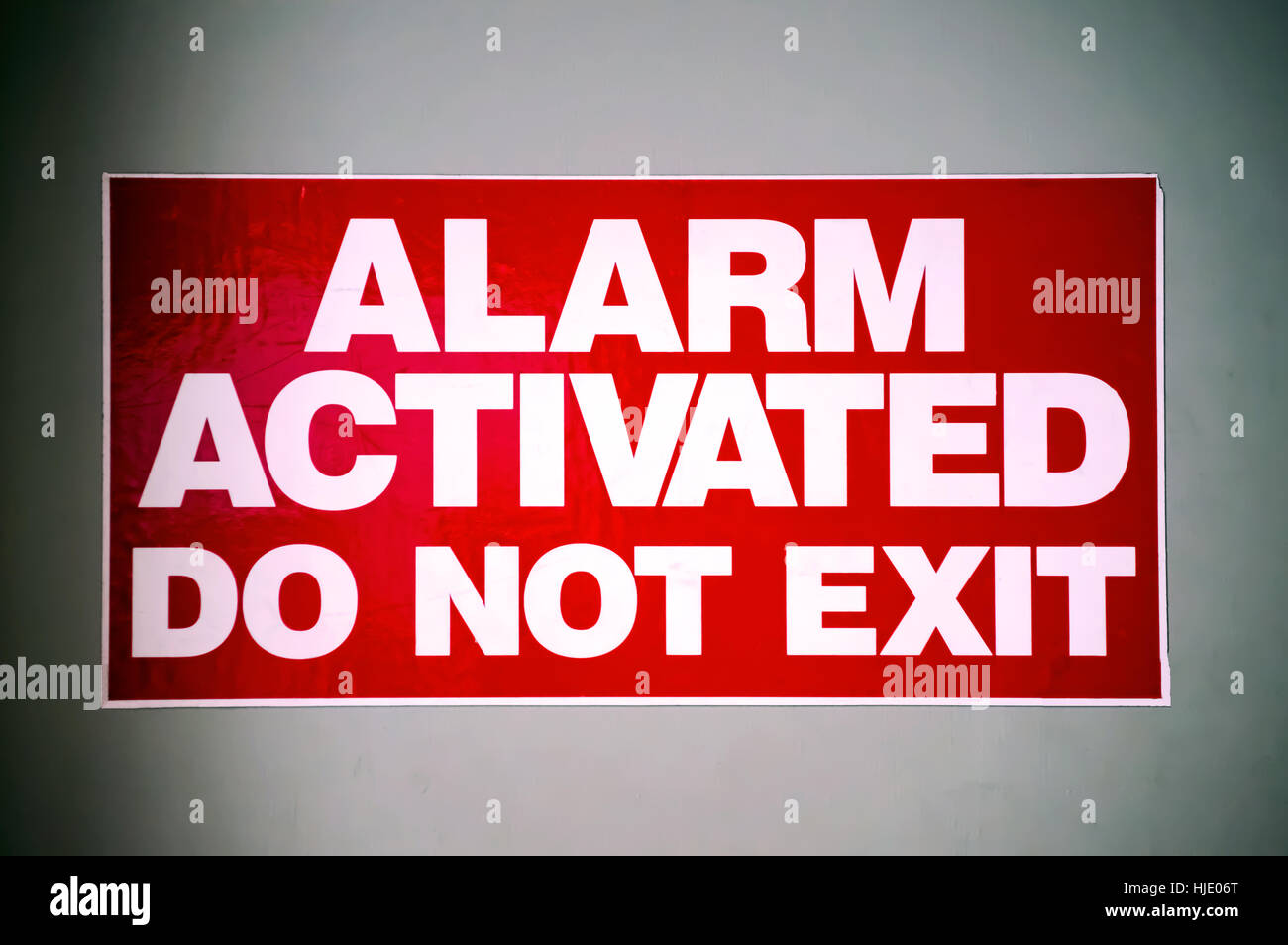A red sign on a white metal background that says: ALARM ACTIVATED. DO ...
