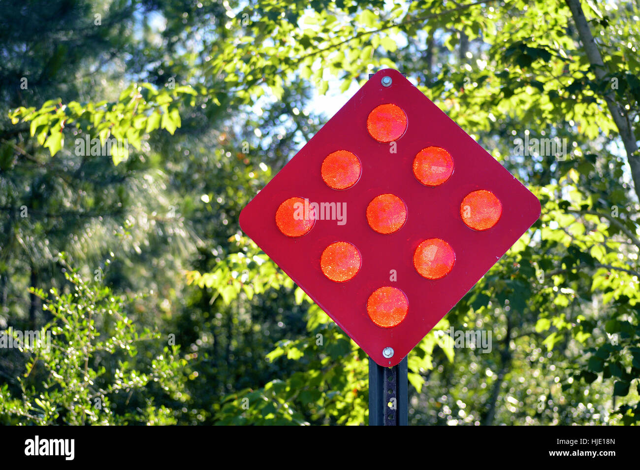 A red caution sign post against a background of a forest Stock Photo ...