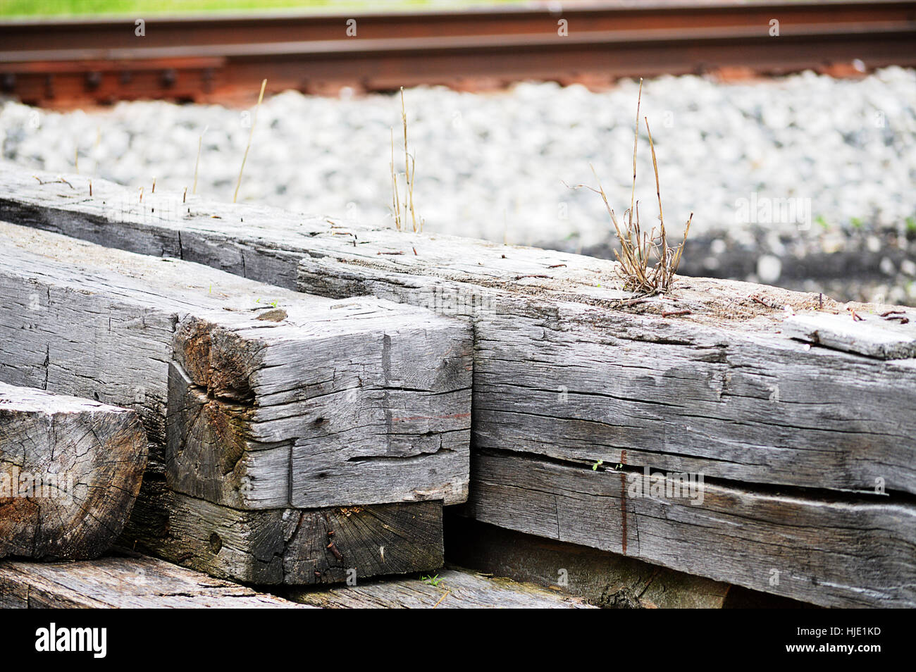 A stack of weather beaten railway ties sitting beside a railroad track ...