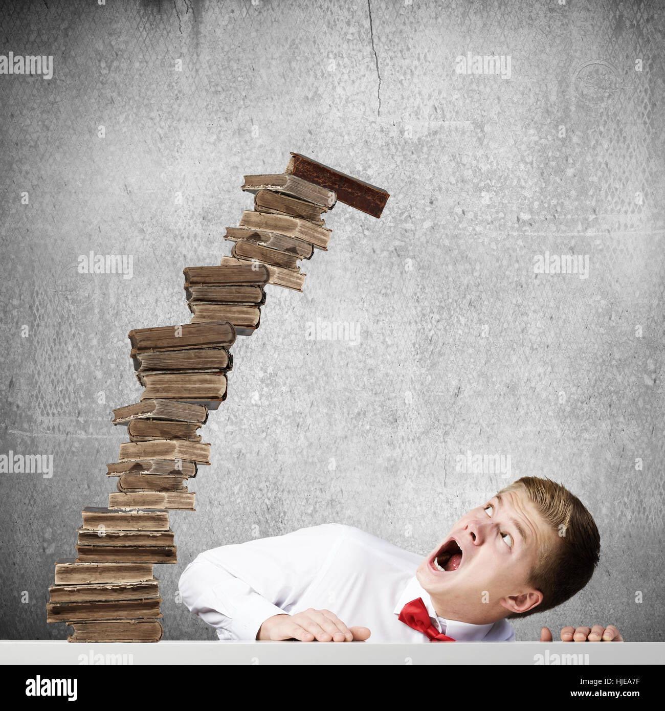 Young handsome businessman and falling pile of books hi-res stock ...