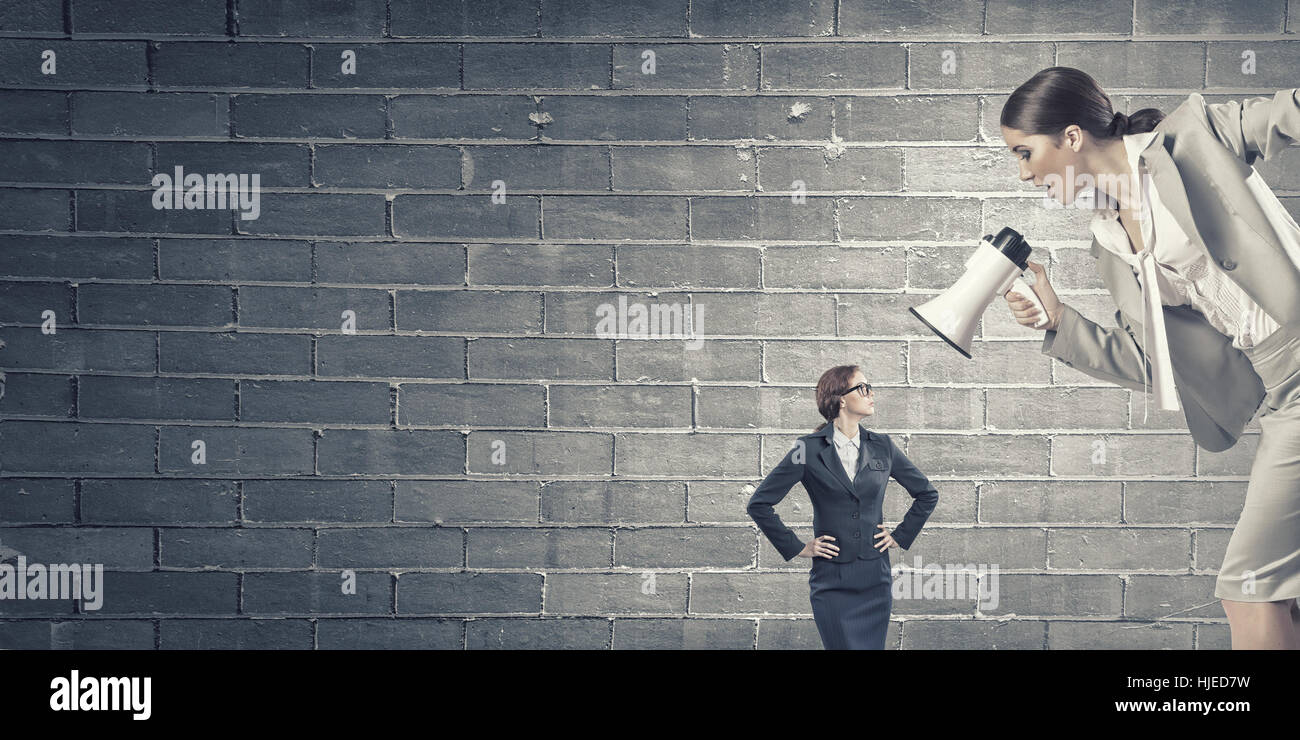 Furious woman screaming agressively in megaphone at woman Stock Photo ...