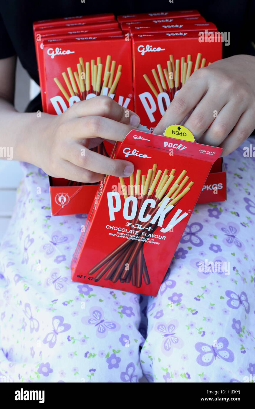 Close up of a young child holding Pocky Chocolate flavour covered ...