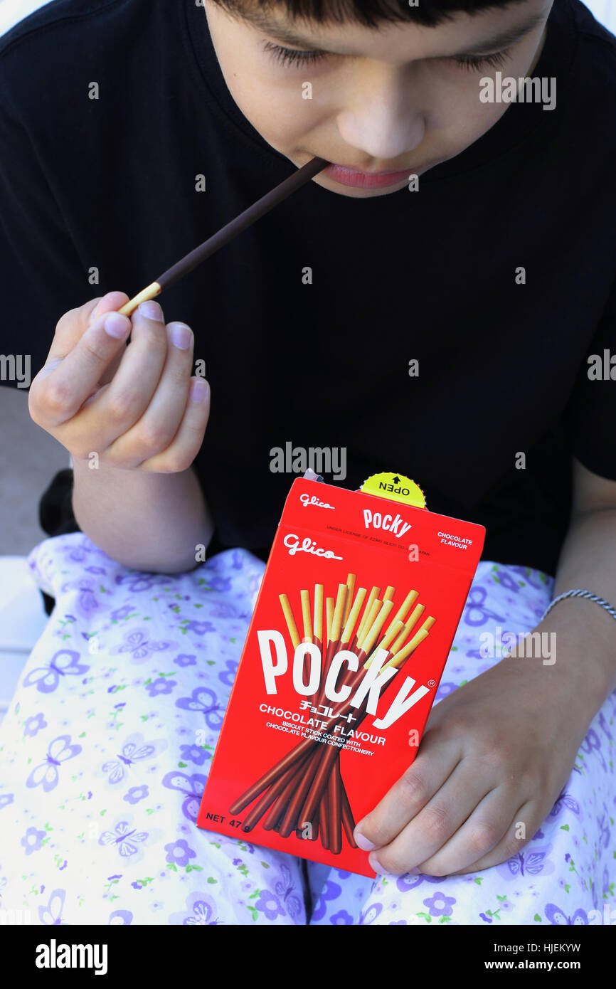 Close up of a young child eating Pocky Chocolate flavour covered ...