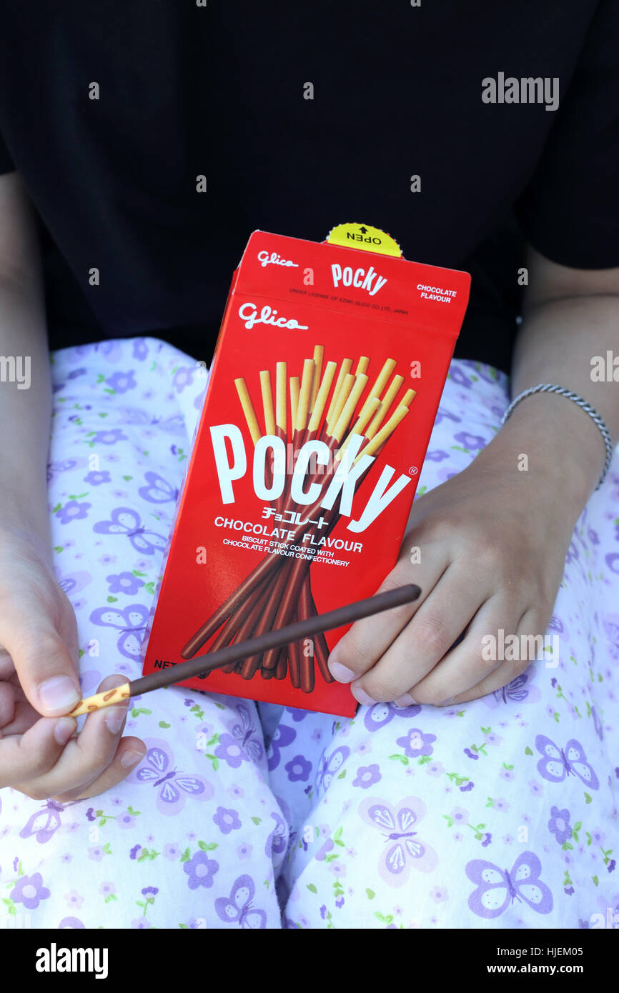 Close up of a young child eating Pocky Chocolate flavour covered ...