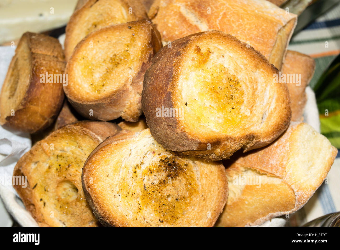 Basket filled with bread and slices of toasted bread seasoned with oil ...