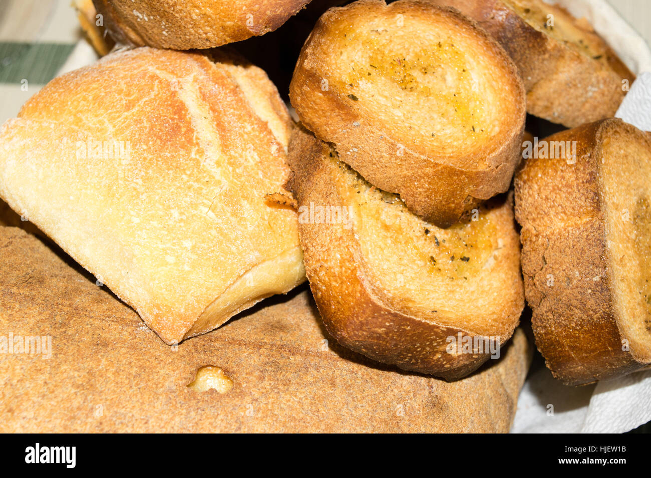 Basket filled with bread and slices of toasted bread seasoned with oil ...