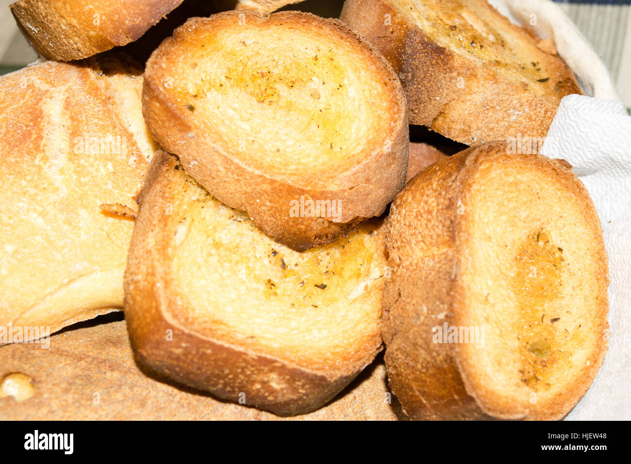 Basket filled with bread and slices of toasted bread seasoned with oil ...