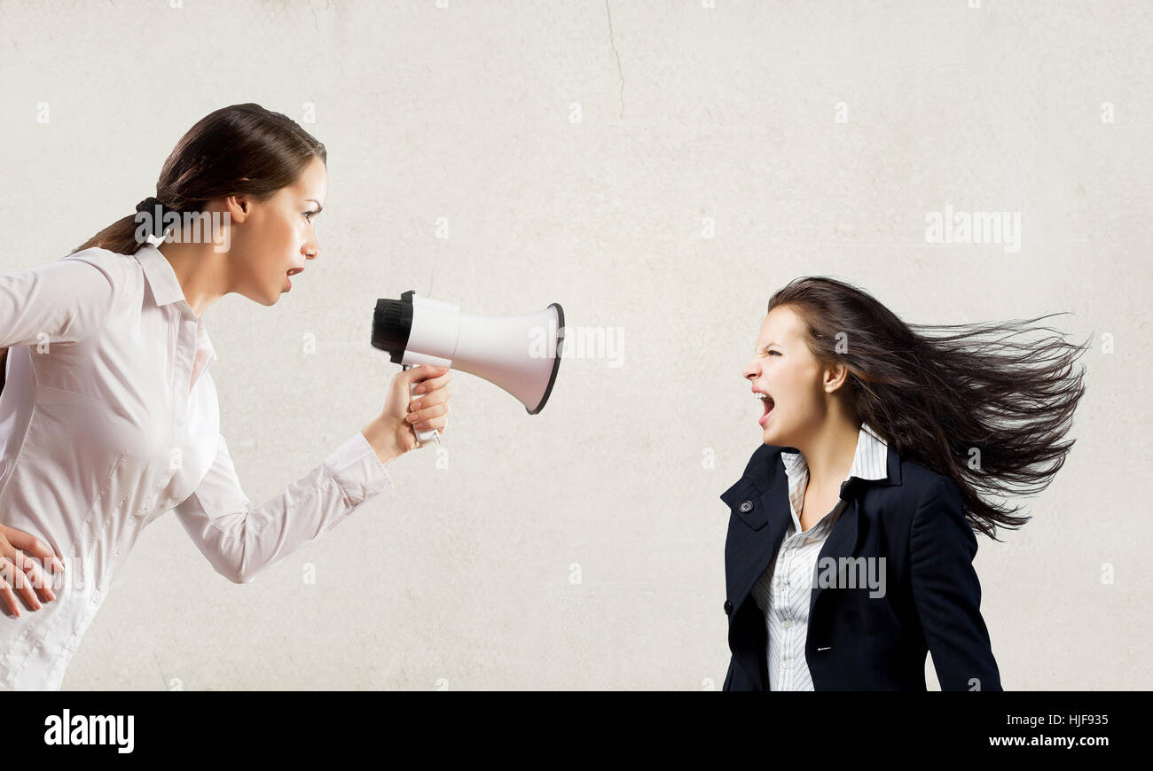 Furious woman screaming agressively in megaphone at woman hi-res stock ...