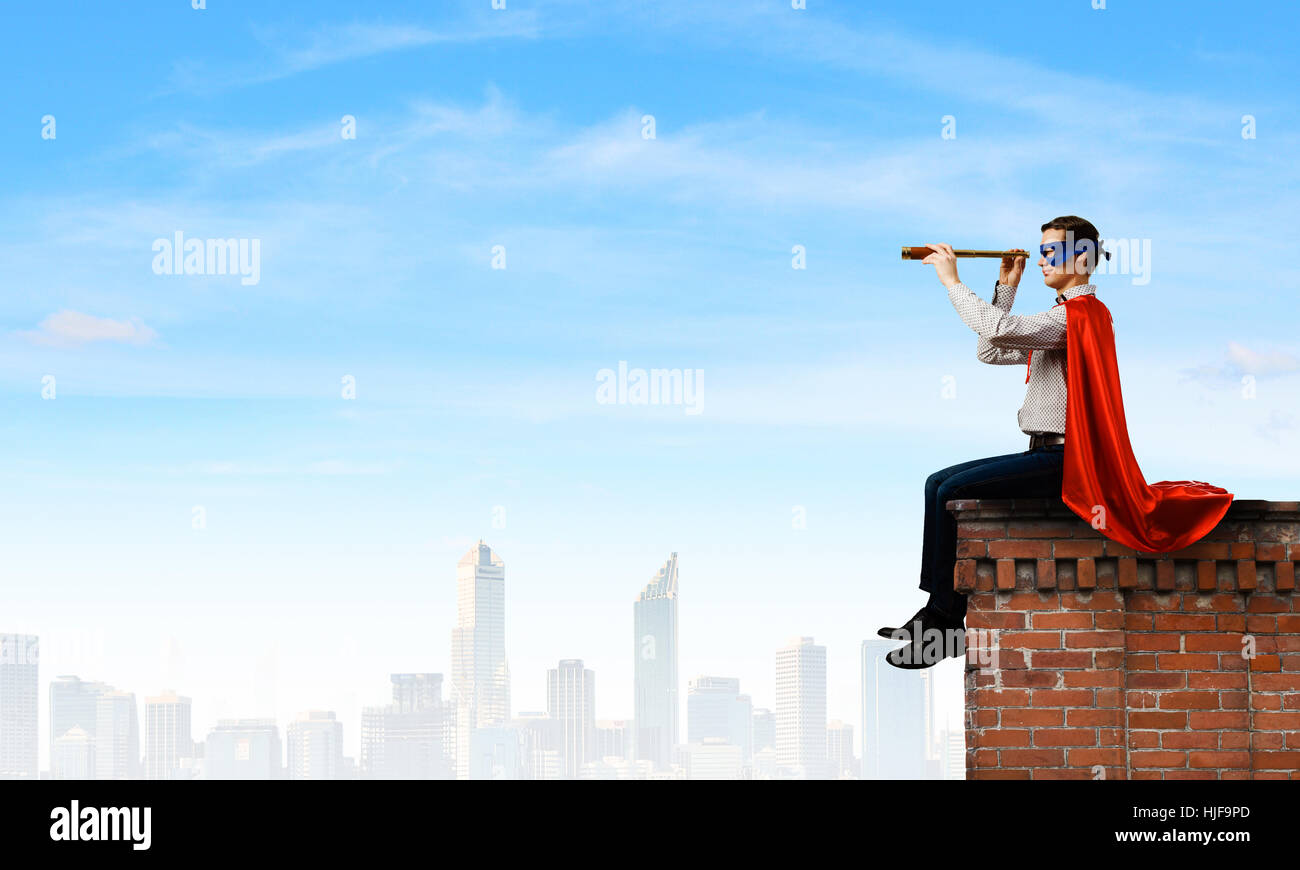 Young man in superhero costume on top of building Stock Photo - Alamy