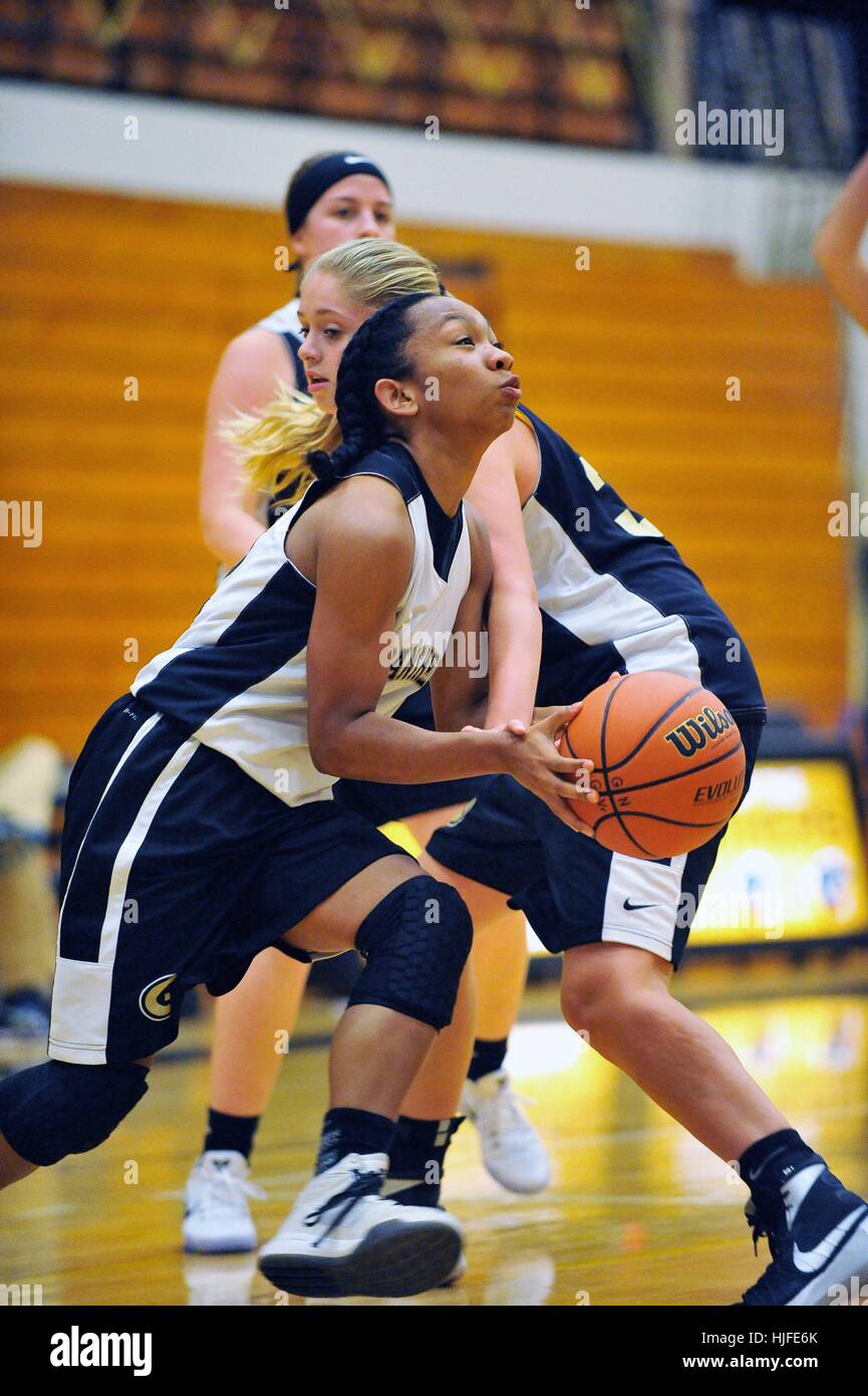 High school guard striving to complete a base line drive to the basket ...