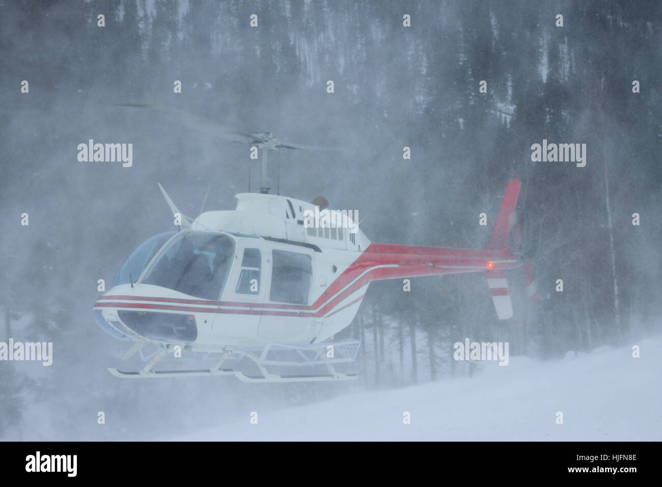 The helicopter landed in the mountains in winter, raising a cloud of ...