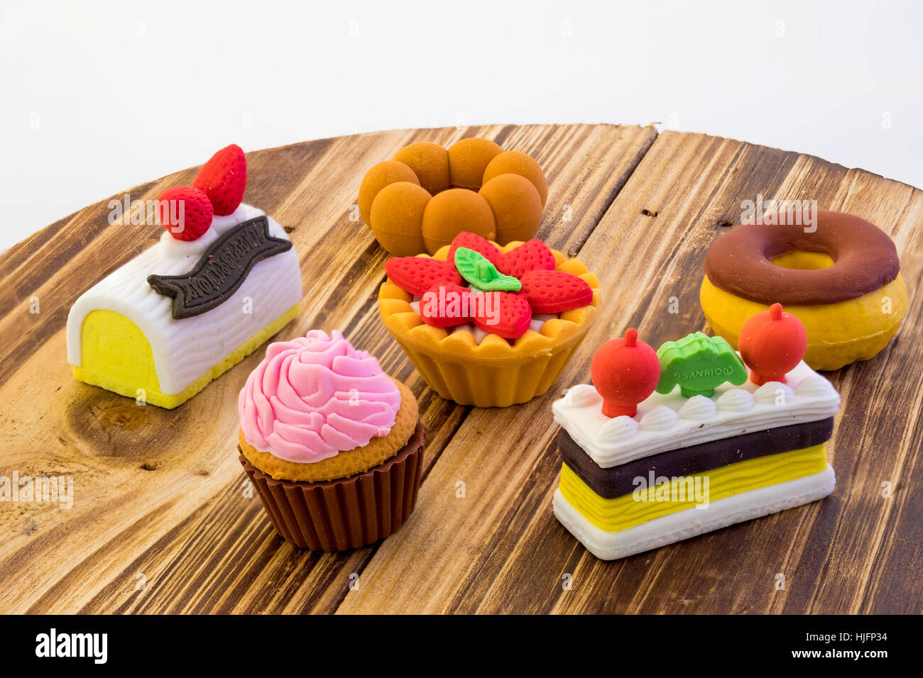 Cute cake eraser party put in a wooden table with white background ...