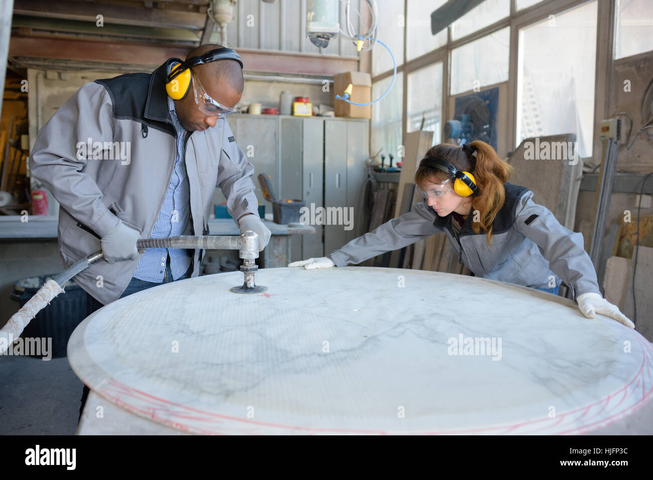 Man sanding large circular structure Stock Photo - Alamy