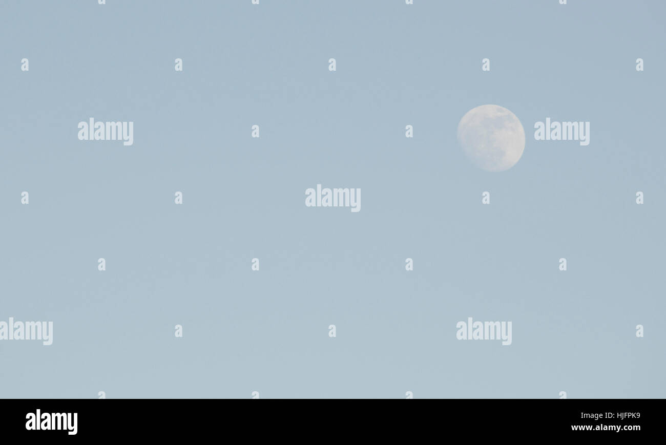Almost full moon on a blue sky in the afternoon Stock Photo - Alamy