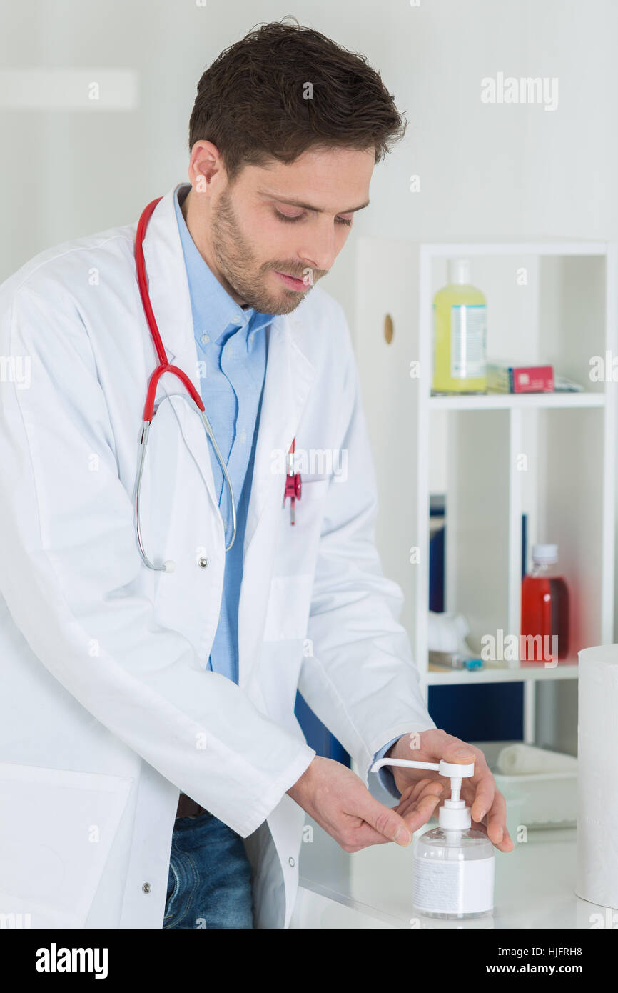 medical doctor using sanitizer dispenser in clinic Stock Photo - Alamy