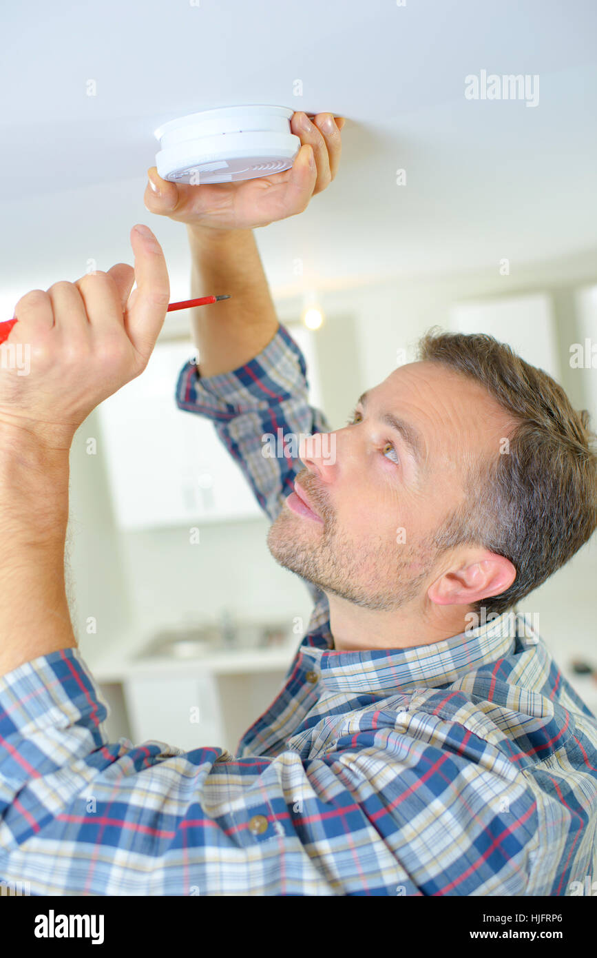Man fitting a smoke alarm Stock Photo - Alamy