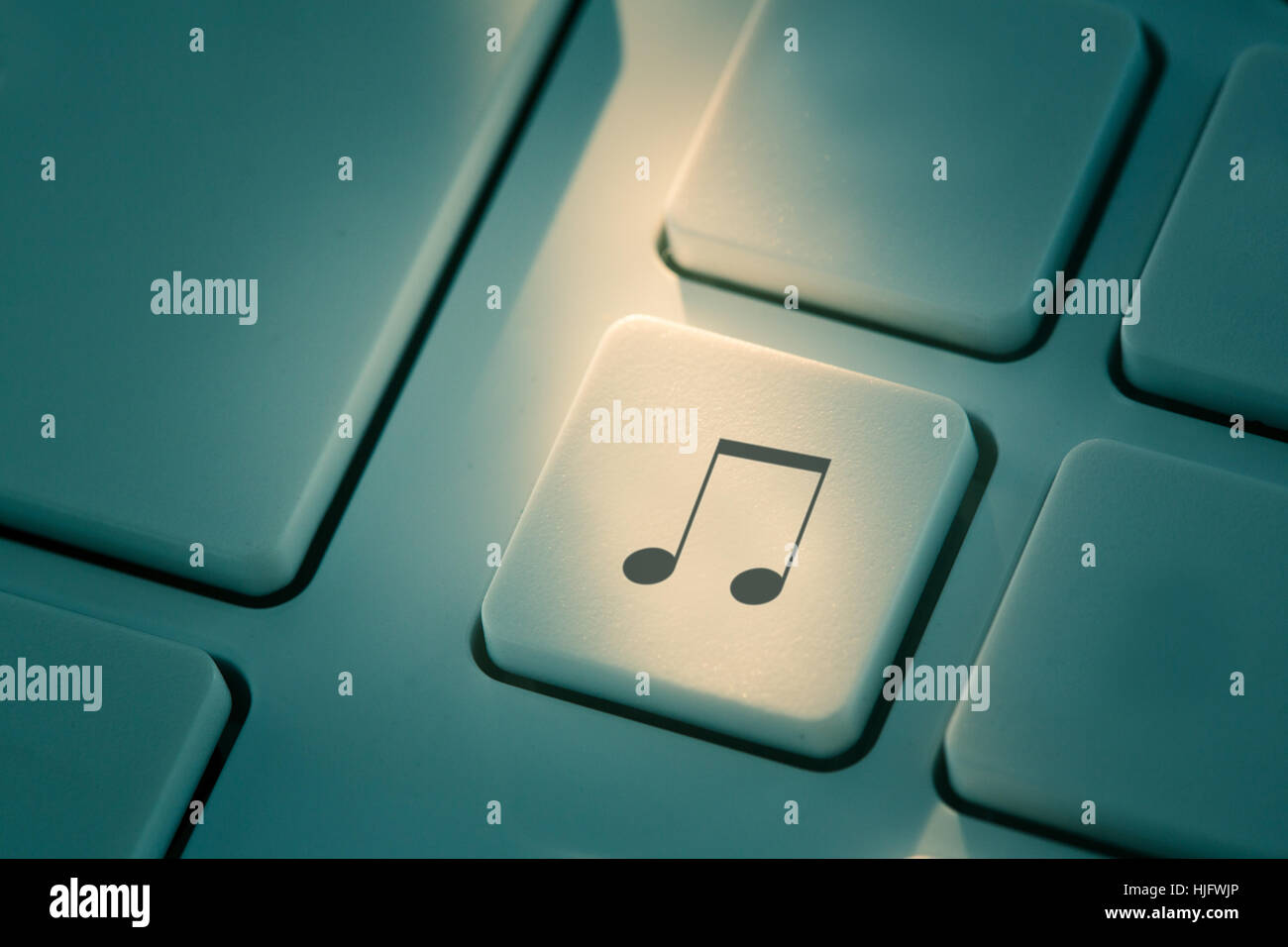 Black music note button on white keyboard Stock Photo - Alamy