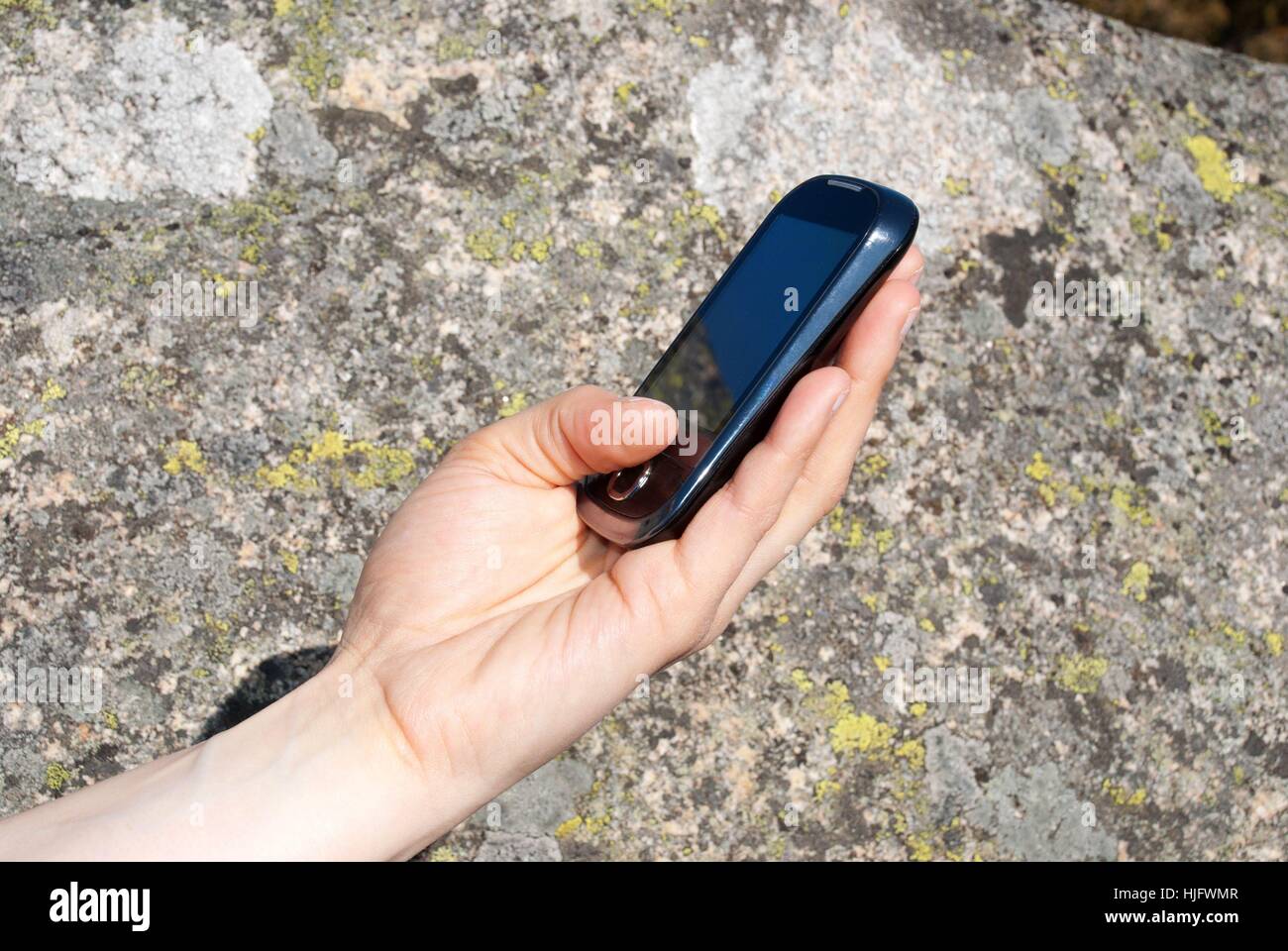 a hand using a smartphone outdoors in the nature Stock Photo - Alamy