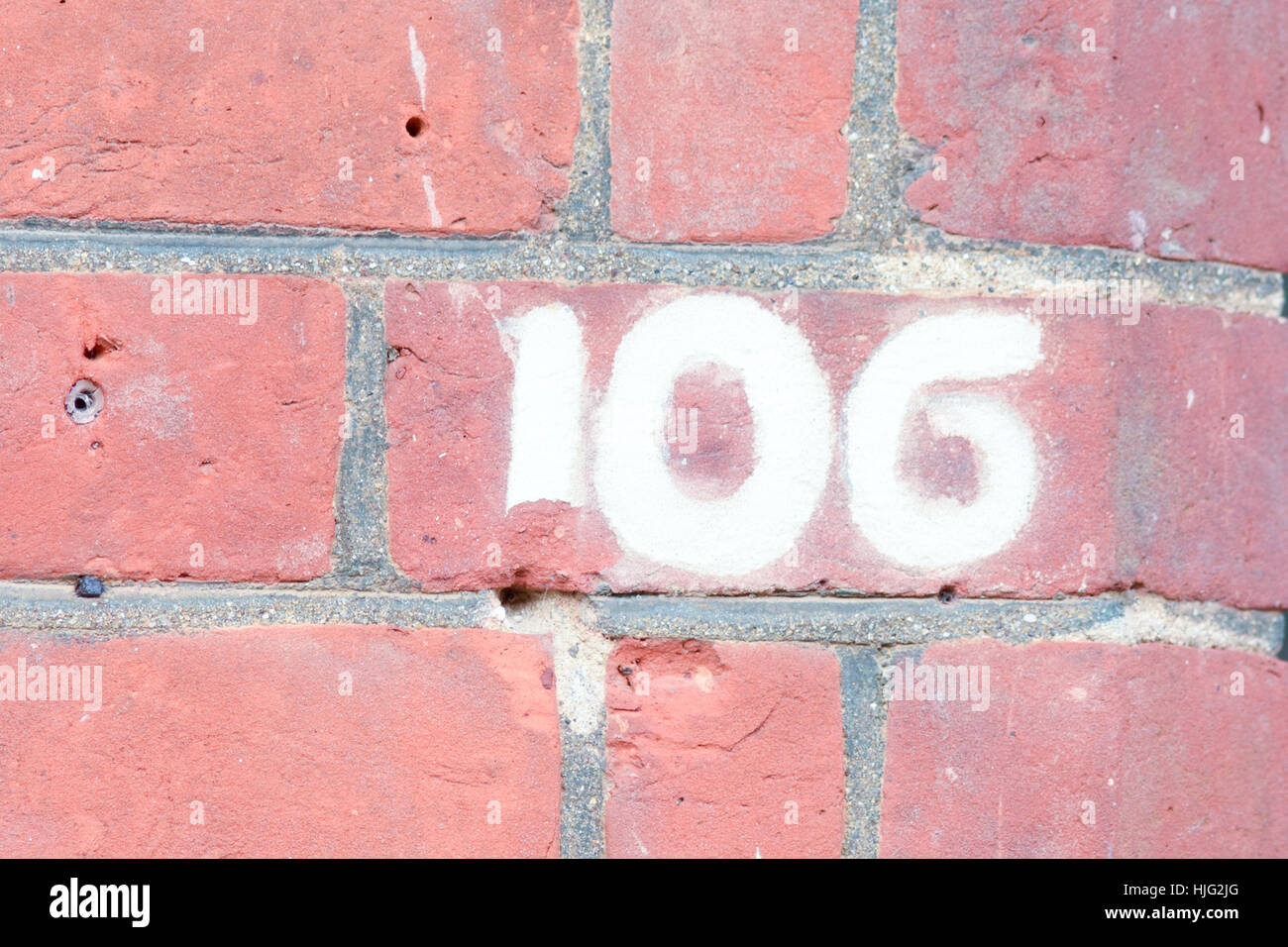 House number 106 painted sign on red brick wall Stock Photo - Alamy