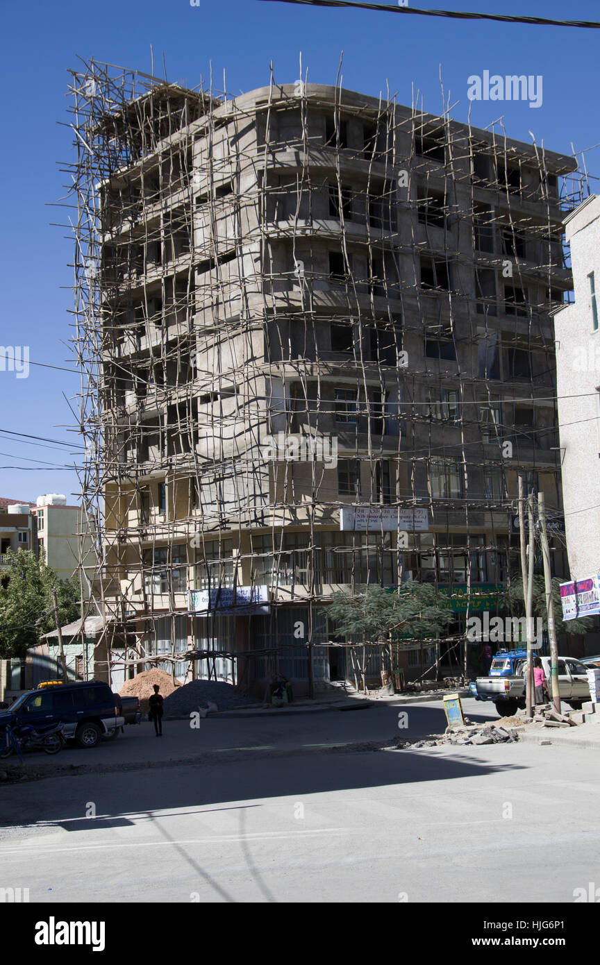 Tree branches scaffolding covering the face of a building in Mekelle ...