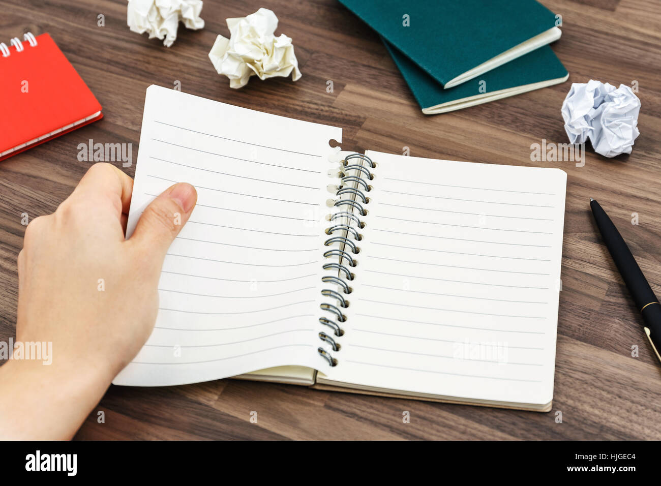 Office table with hand tearing paper from notebook Stock Photo - Alamy