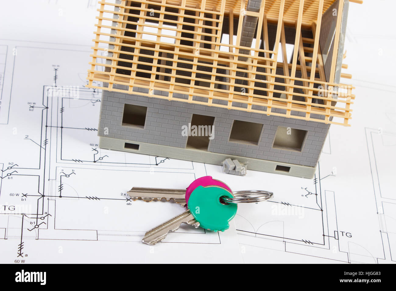 Home keys and small house under construction lying on electrical ...