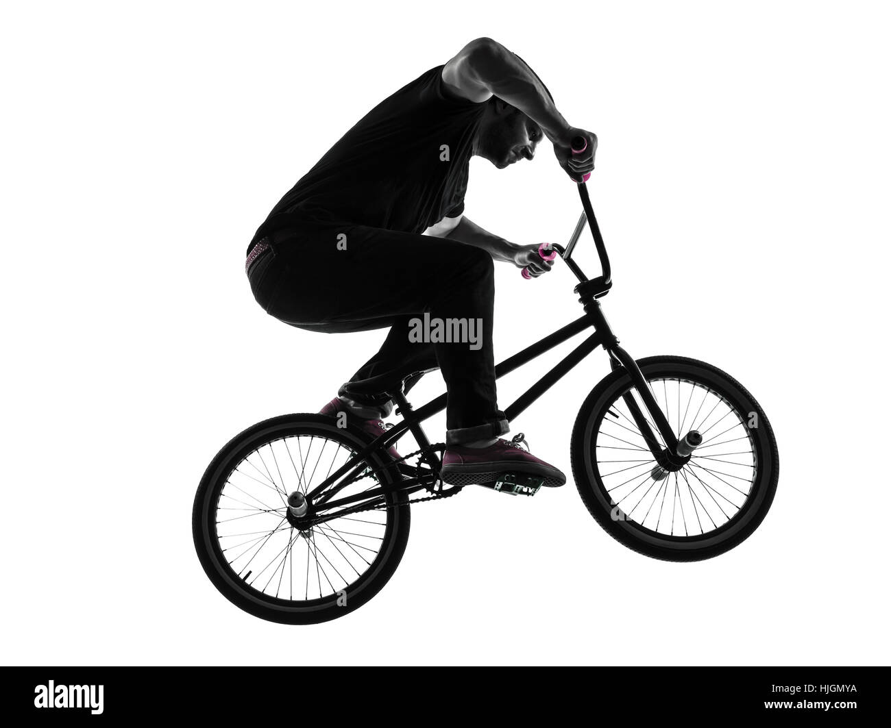 one caucasian man exercising bmx acrobatic figure in silhouette studio ...