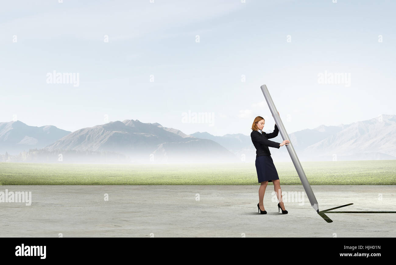 Young businesswoman drawing arrow with big pencil Stock Photo - Alamy