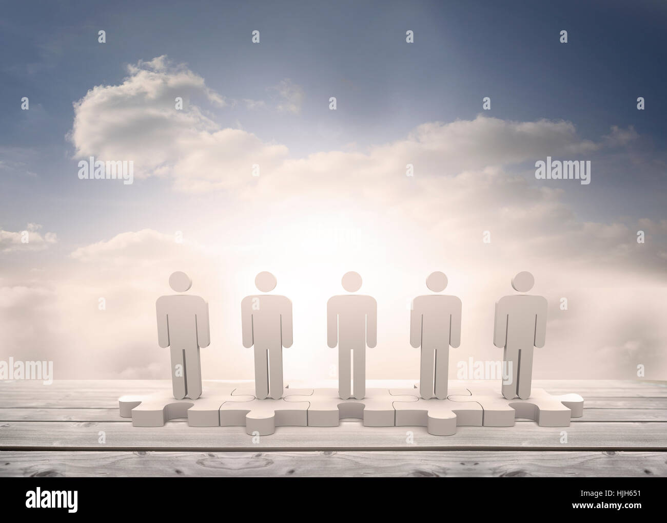 Human figures standing in line on jigsaw pieces on wooden boards with ...