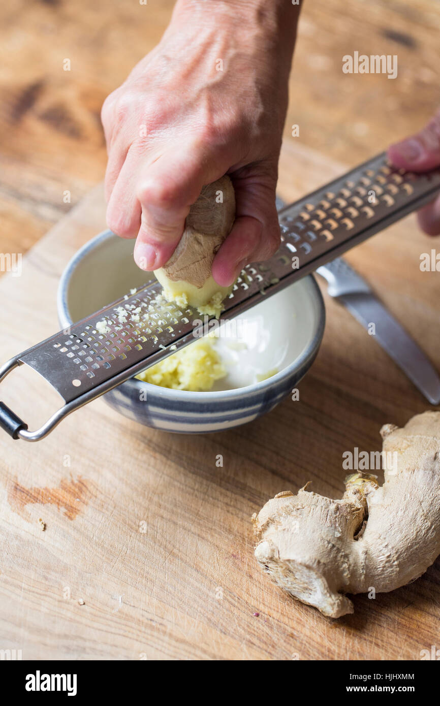 Woman grating ginger Stock Photo - Alamy