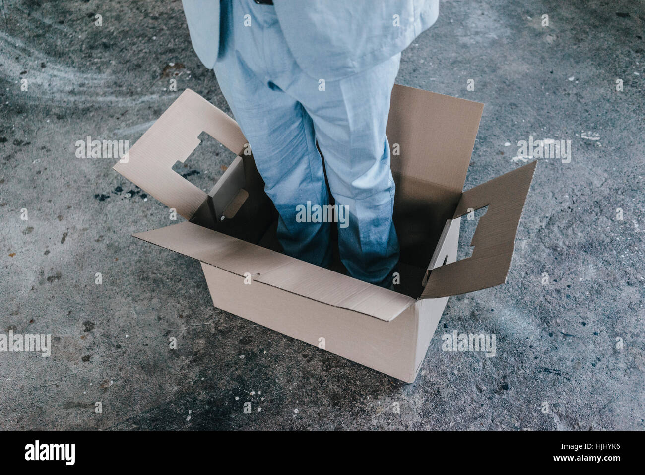 Businessman standing inside cardboard box Stock Photo - Alamy